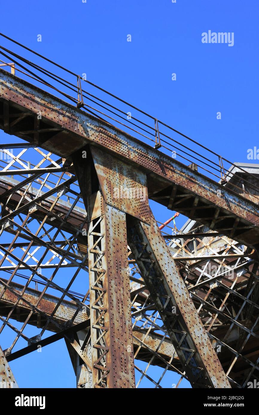 A very tall steel truss structure standing in the industrial district ...