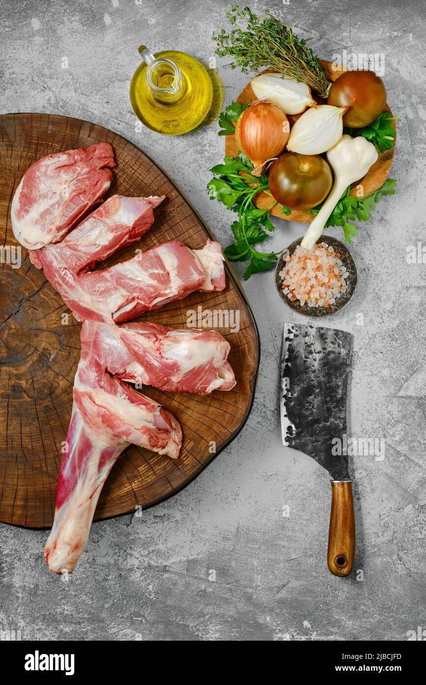 Raw lamb shoulder half cut on wooden slab, top view Stock Photo - Alamy