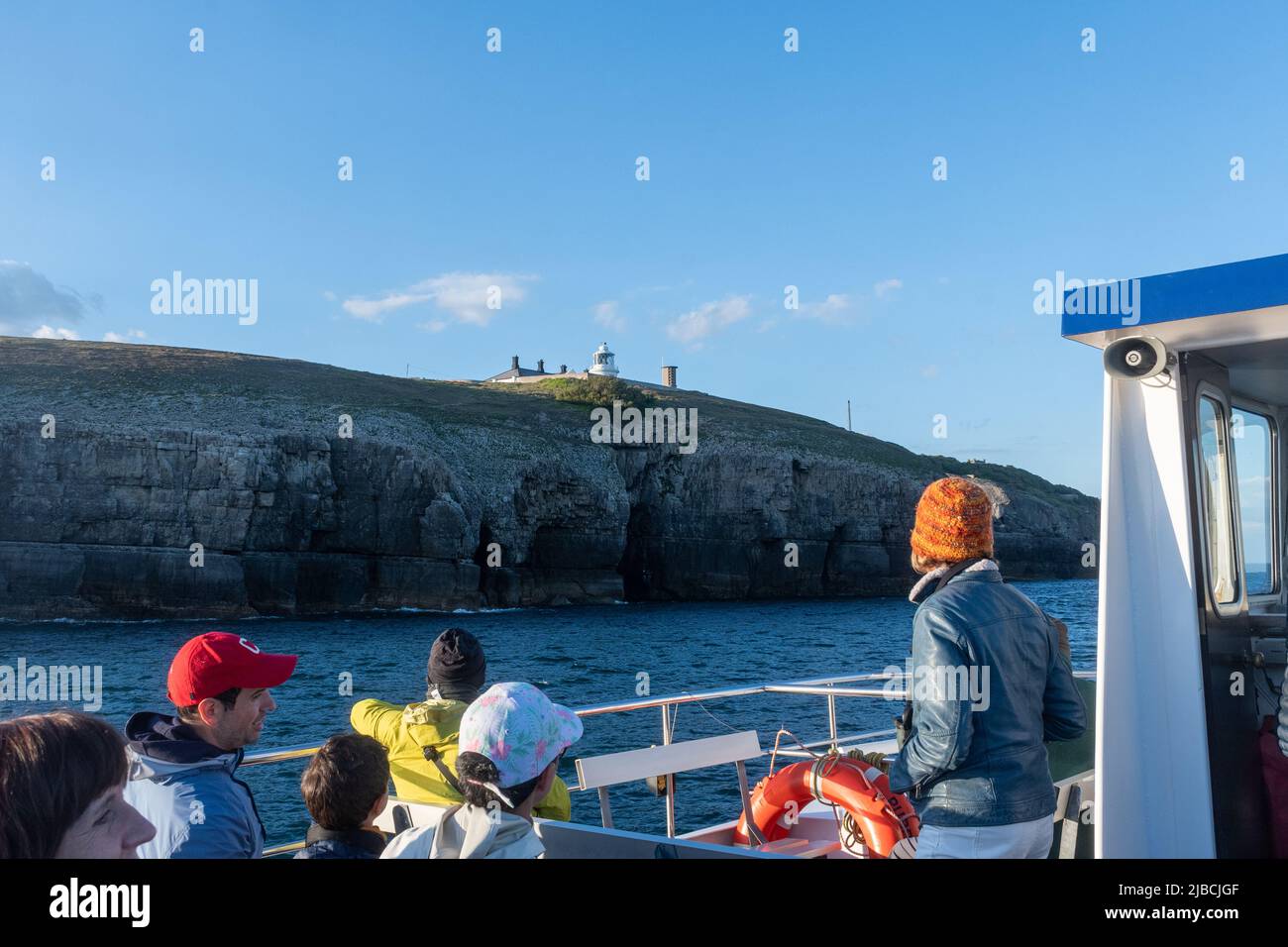 Boat trip passengers looking at Anvil Point Lighthouse on the Jurassic ...