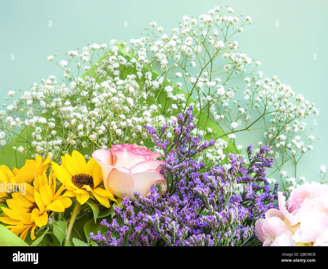 Colorful beautiful spring bouquet closeup. Roses, sunflower, purple ...