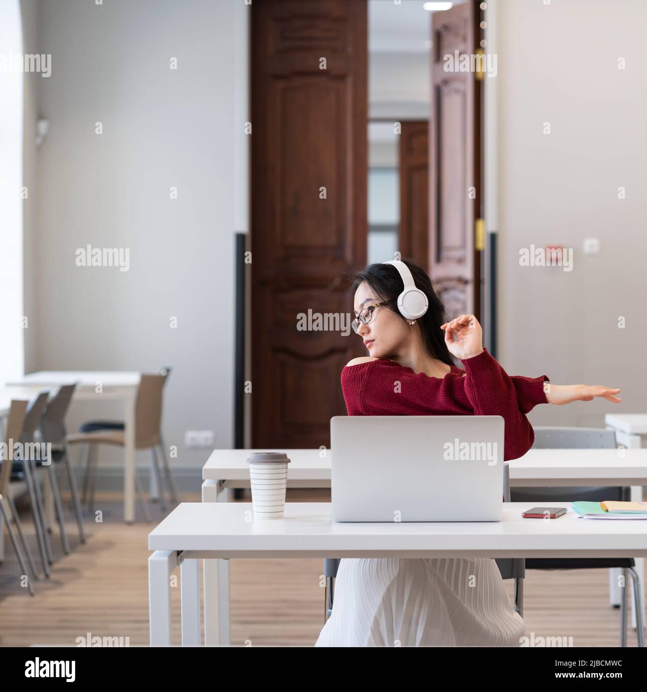 Asian female student doing gymnastics exercises, resting from computer ...