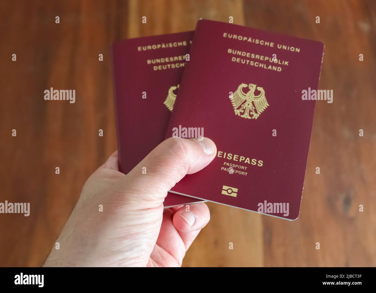 A male hand holds two German passports for passport control Stock Photo ...