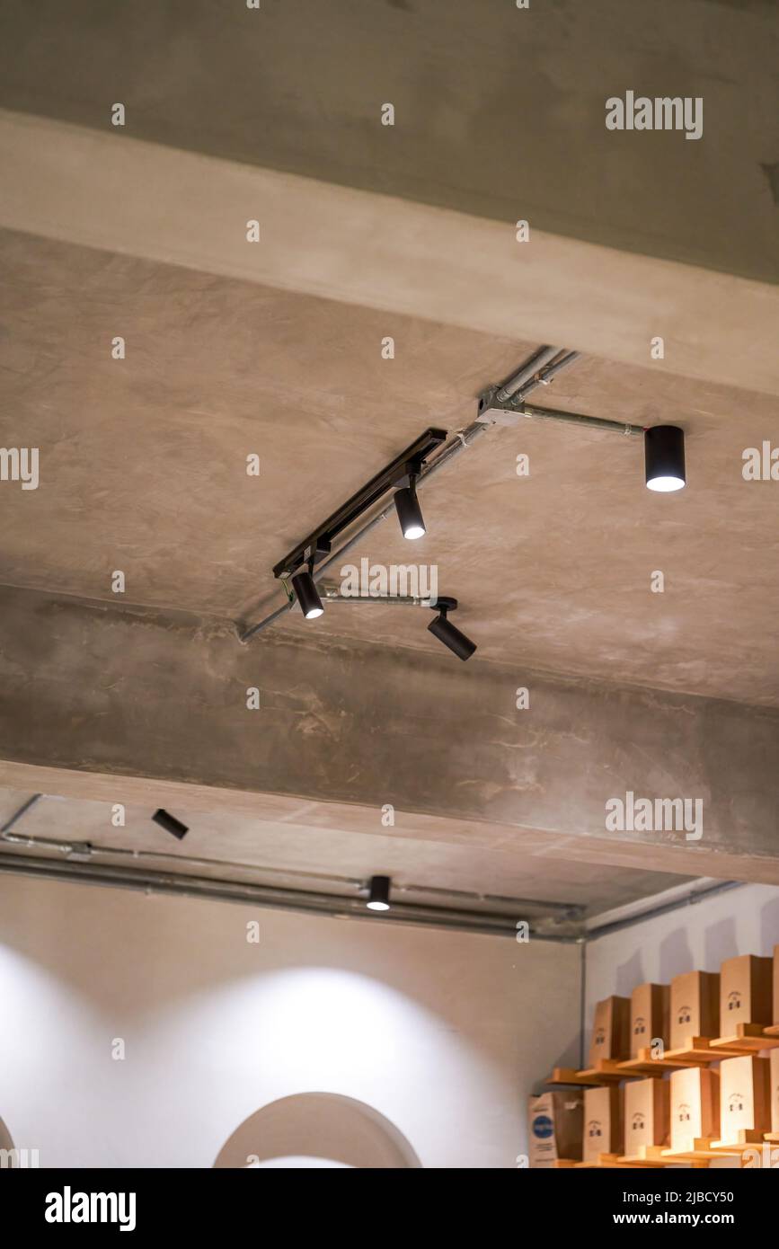 Closeup of black spotlights on cement ceiling Stock Photo - Alamy