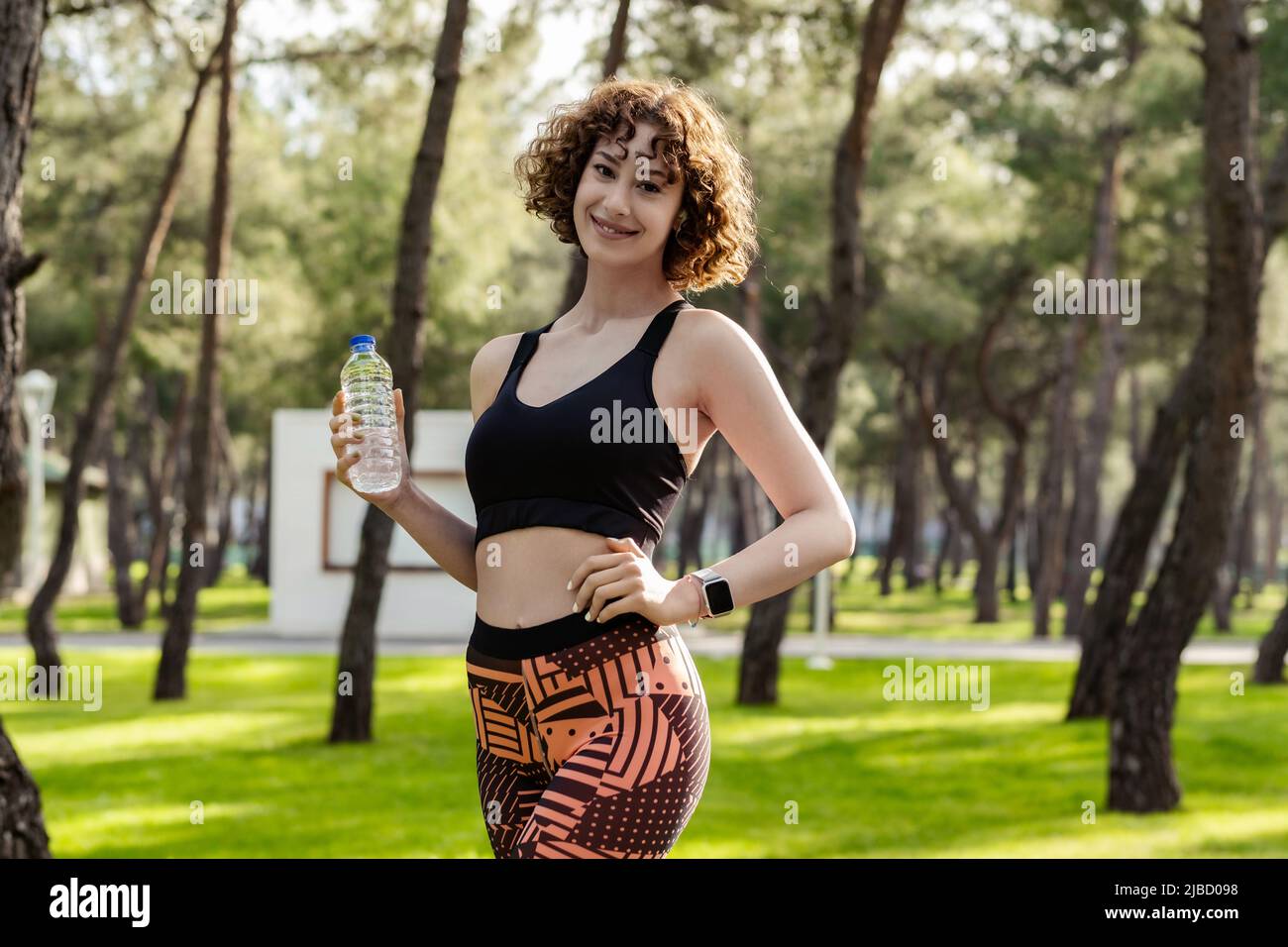 Cute caucasian woman wearing black sports bra standing on city park ...