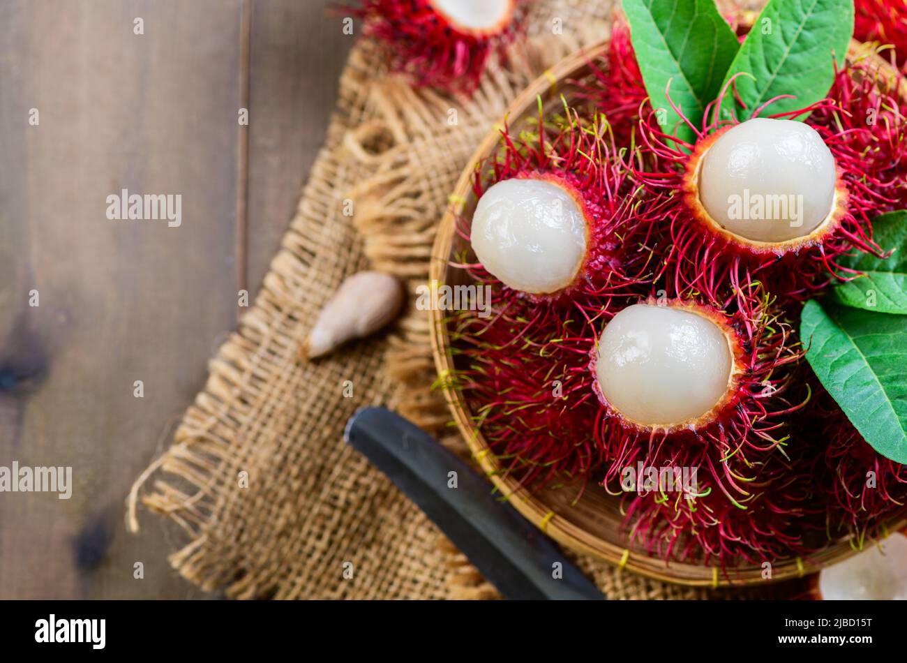 Top view of Fresh Rambutan fruits with leaves on bamboo basket isolated ...
