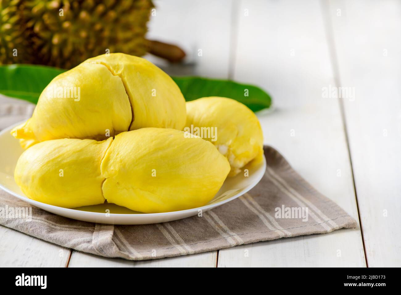 Fresh durian (monthong) on white dish and white wood background, king of fruit from Thailand on ...