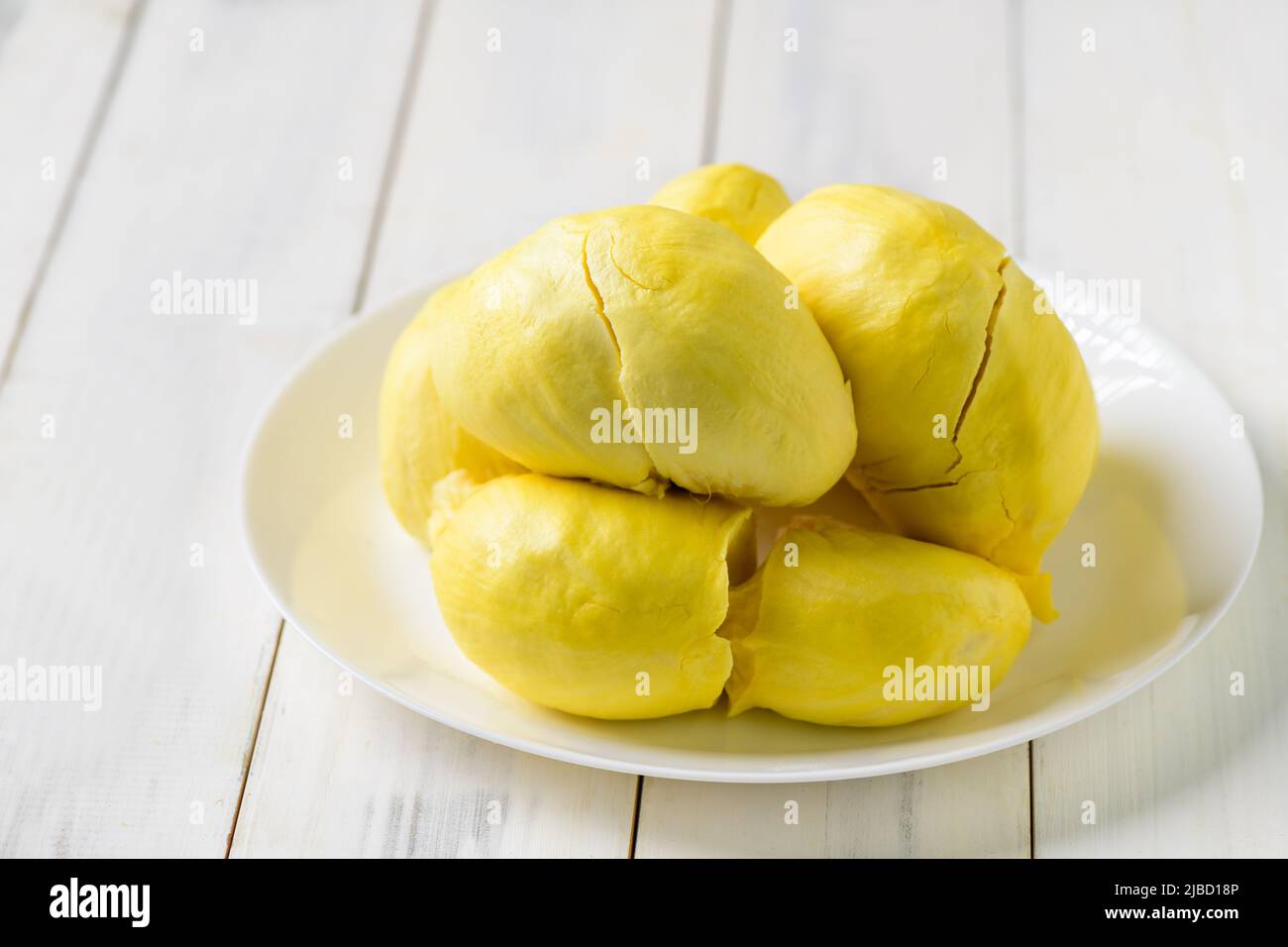 Fresh durian (monthong) on white dish and white wood background, king of fruit from Thailand on ...