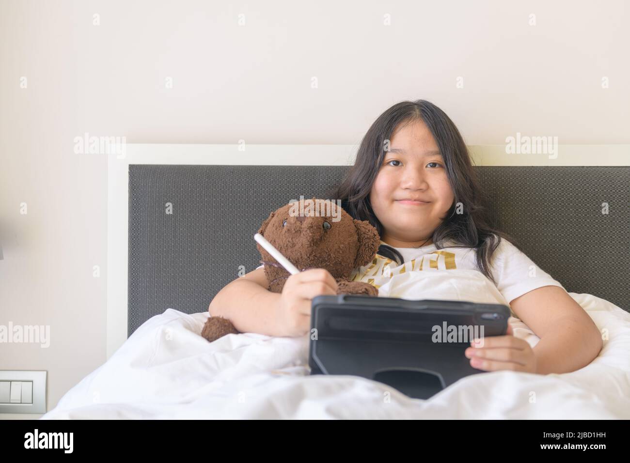 Cute girl studying online with tablet pn bed, new normal and education ...