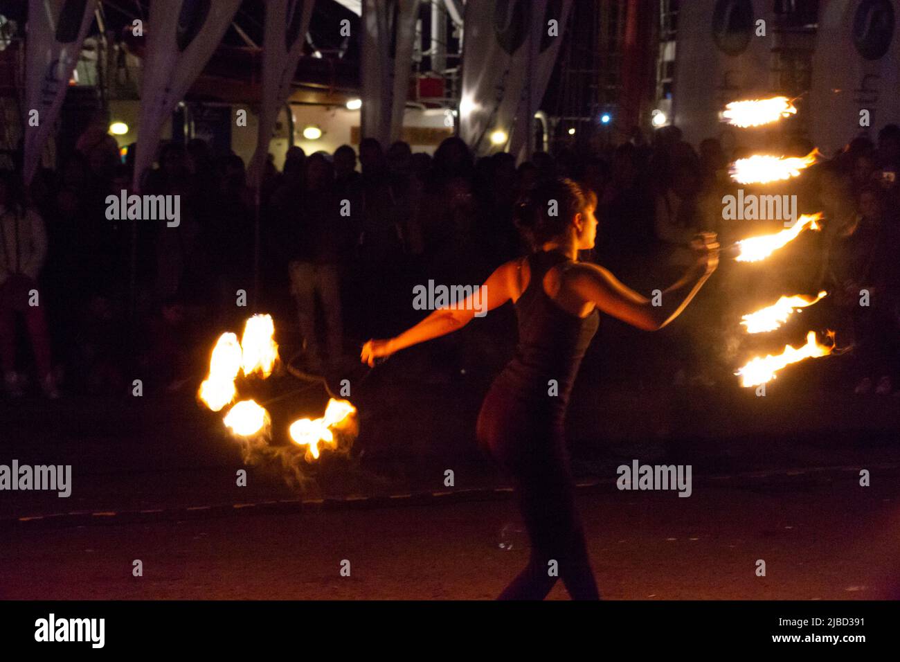 Young woman dancing dance with fire fan in her hand.fire show at Varna ...