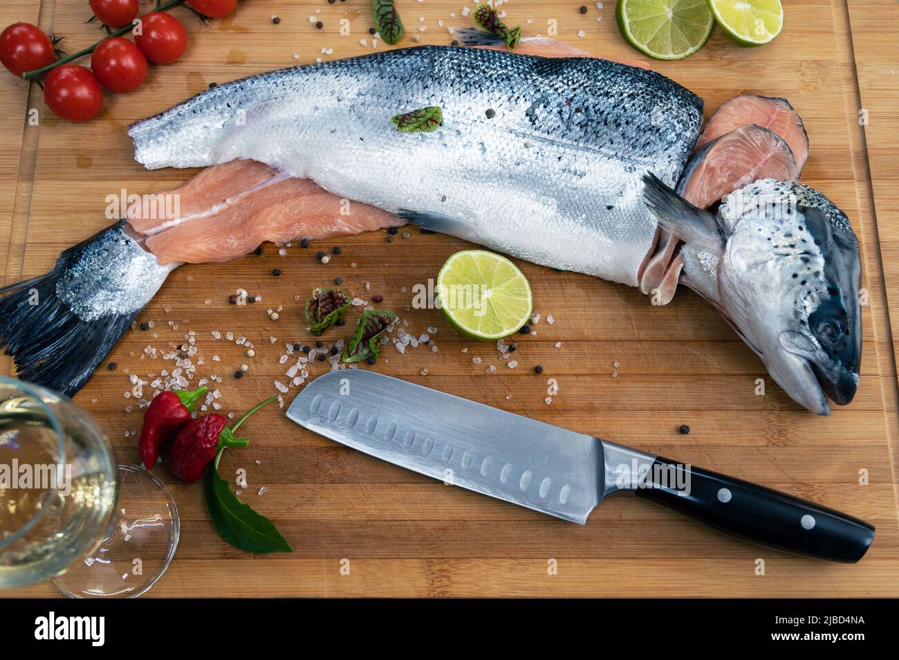 Fresh raw salmon fish on the kitchen wooden board with spices and lime ...