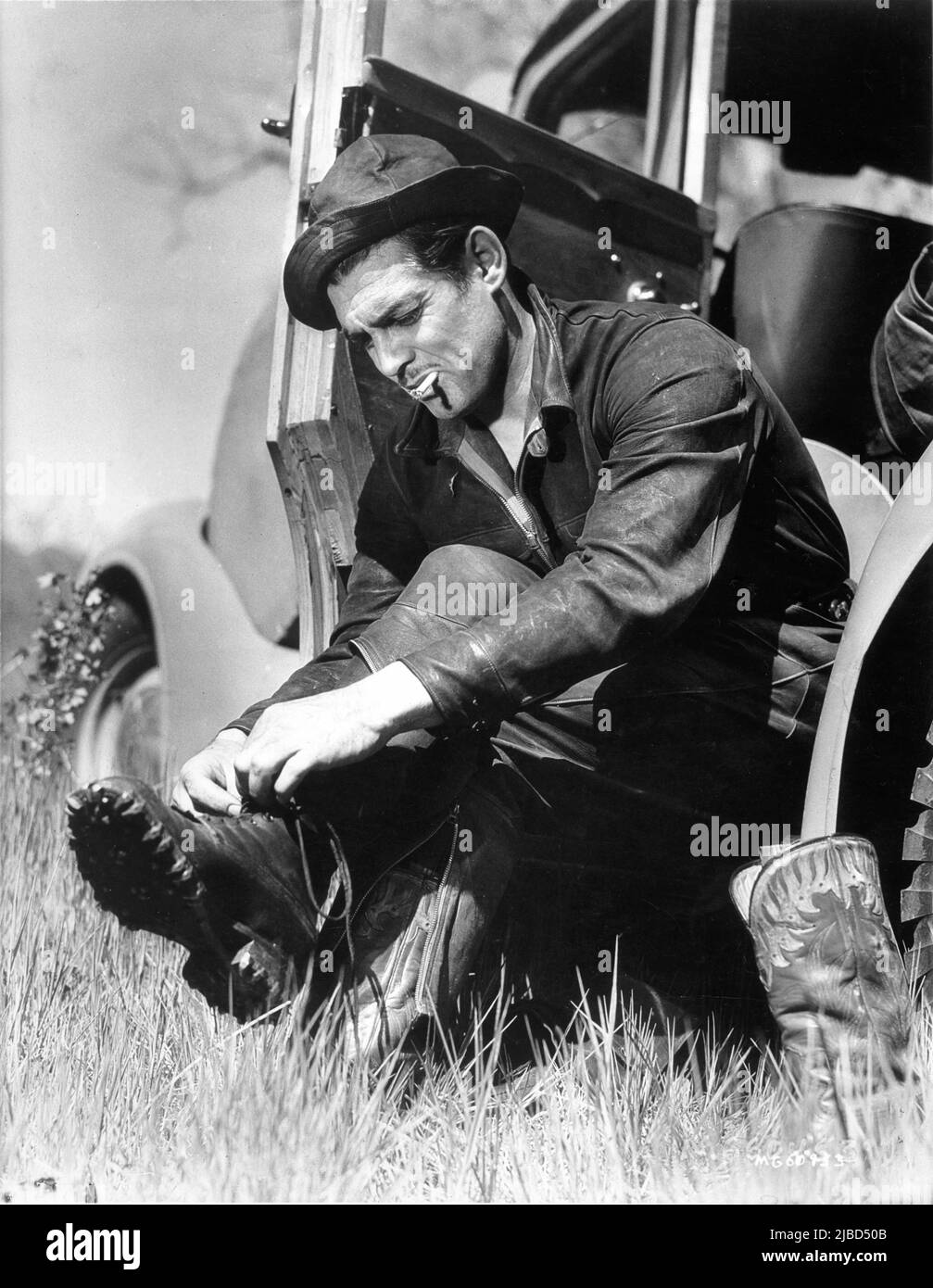 CLARK GABLE putting his boots on during Hunting Trip in April 1937 ...