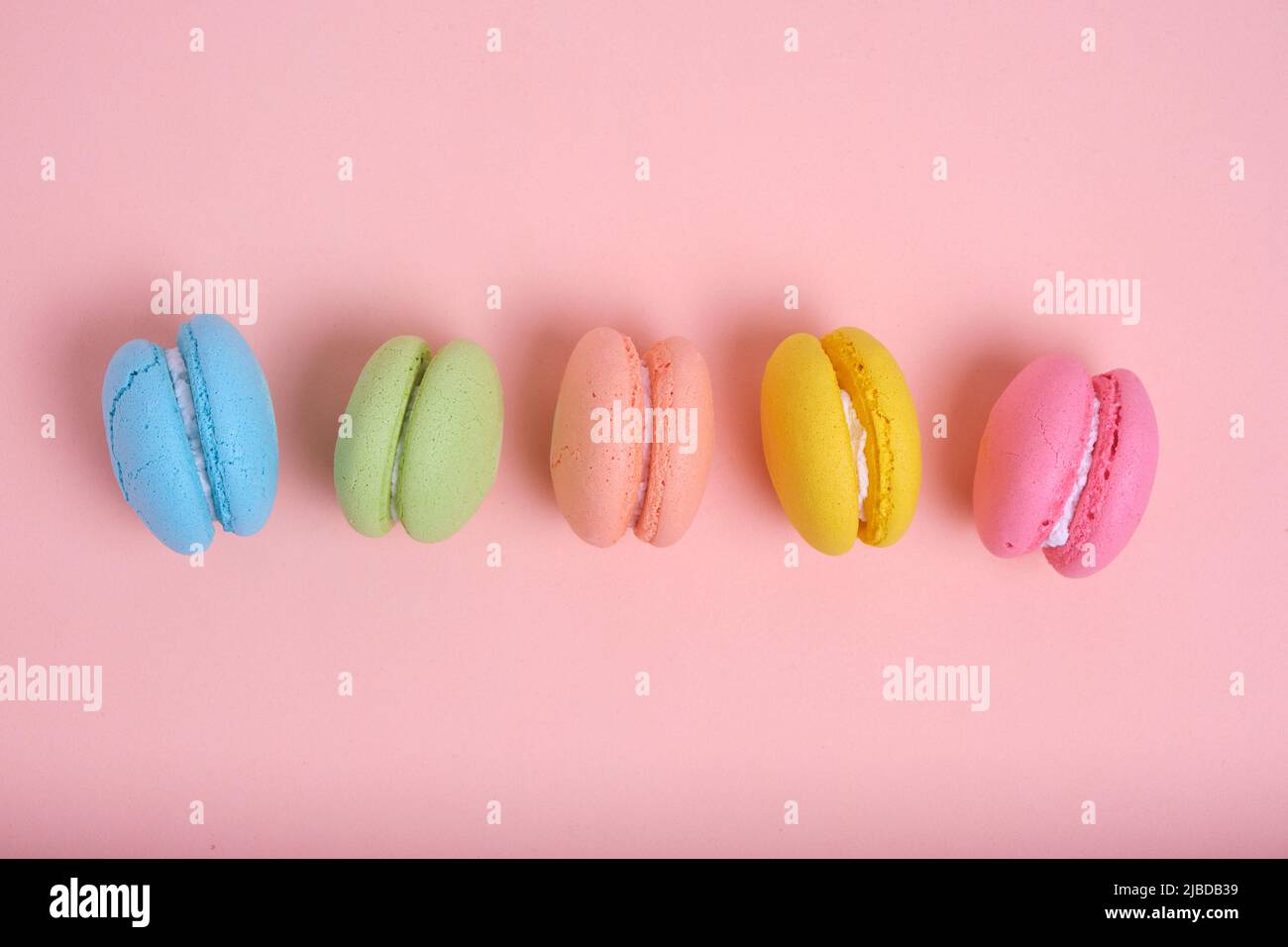 Colorful and bright macarons cookies pink background Stock Photo - Alamy