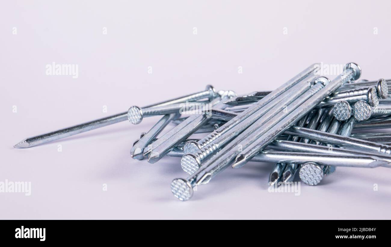 Construction nails in stack on a white background Stock Photo - Alamy