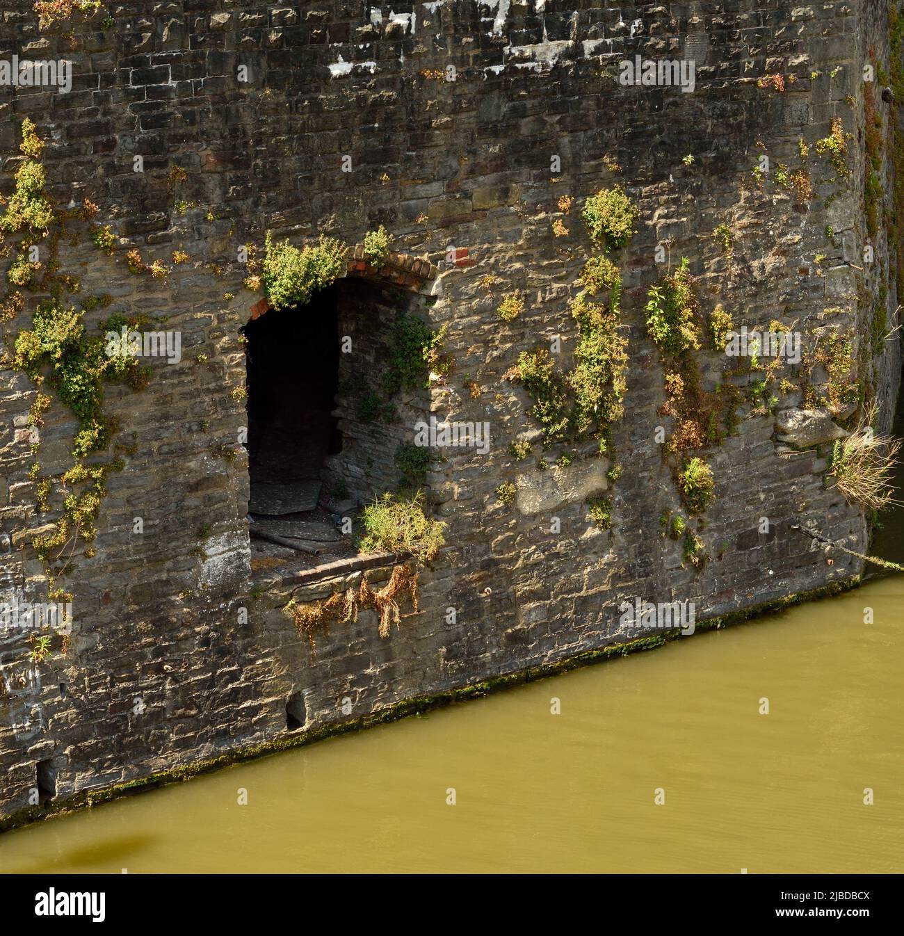 Hole in a medieval wall by the river Stock Photo - Alamy