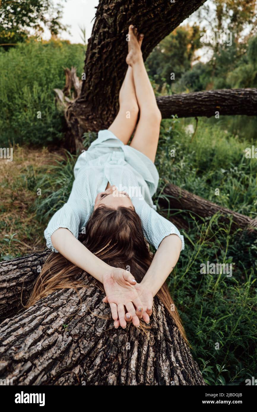 Nature and mental health. Barefoot woman in a dress is resting near the ...