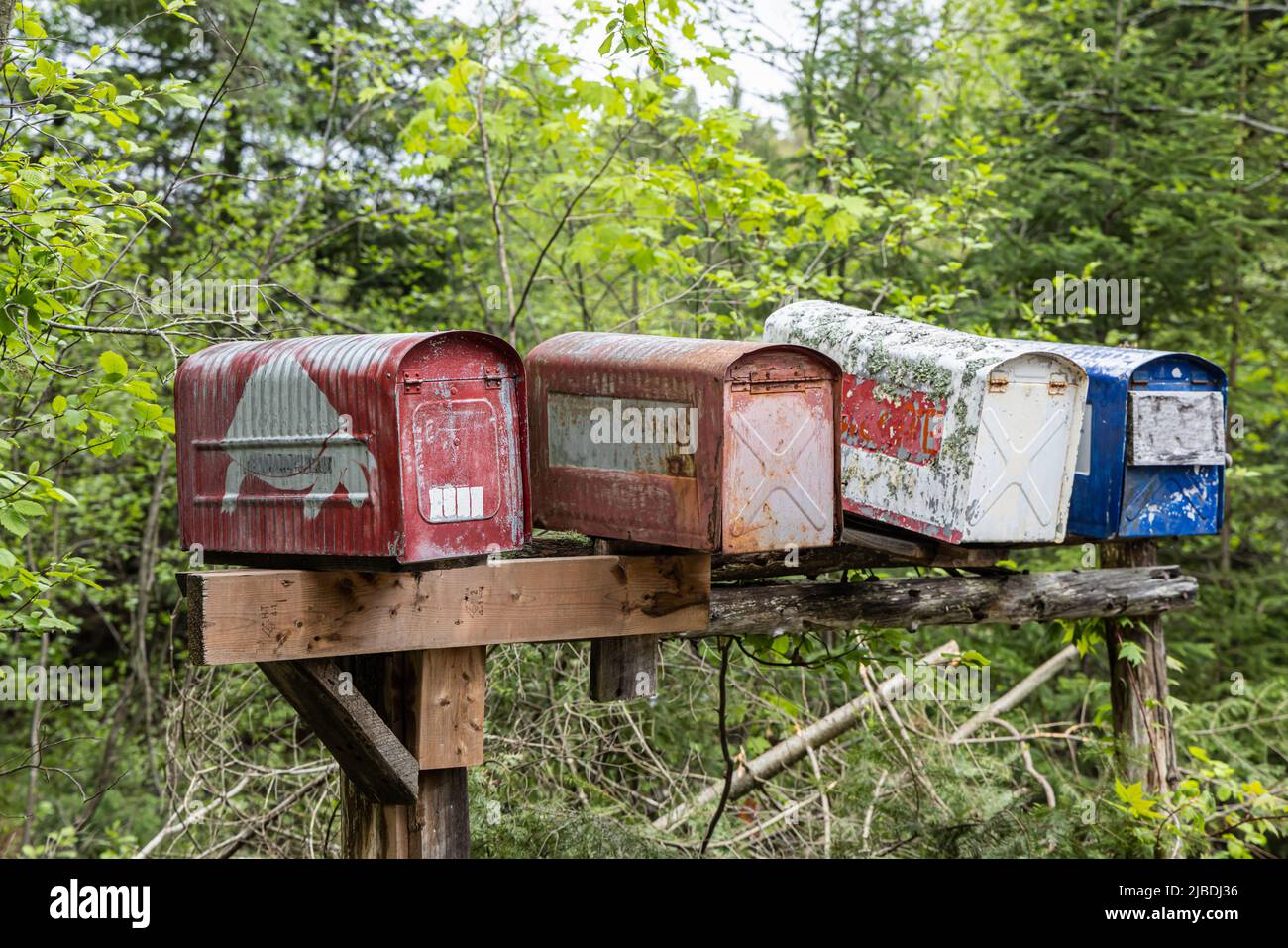 Closeup selective focus view of four old rusty mailboxes on a totting ...