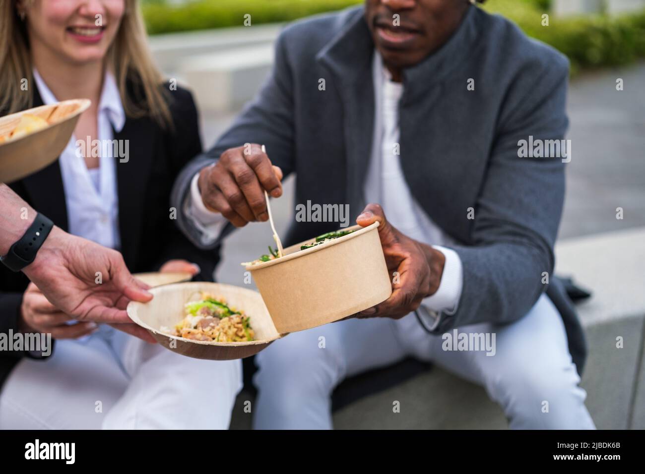 Two unrecognizable co-workers sharing healthy food on break Stock Photo ...