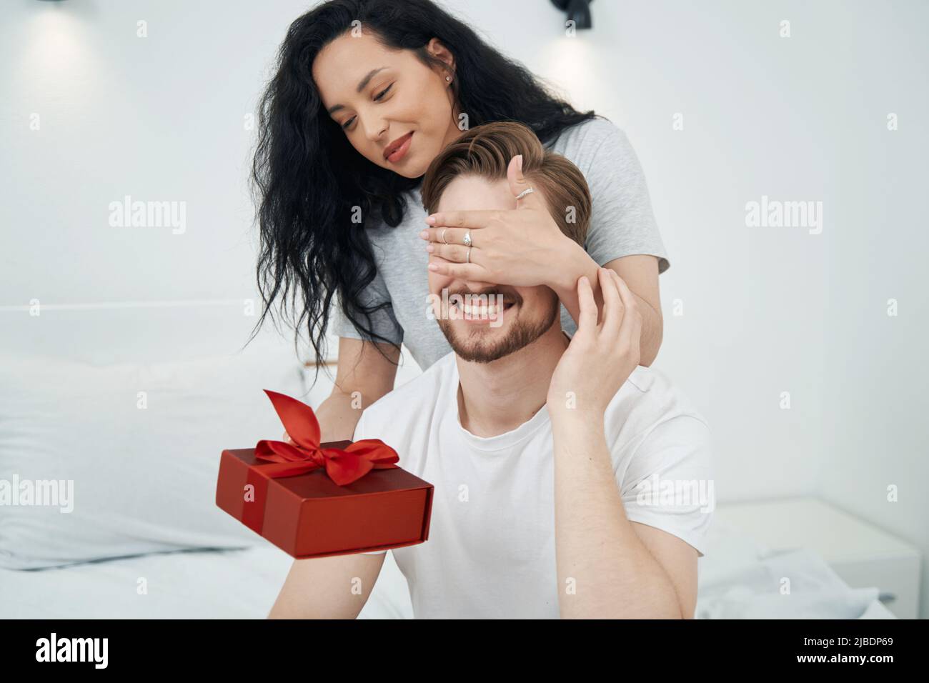 Romantic woman presenting gift to beloved person Stock Photo - Alamy