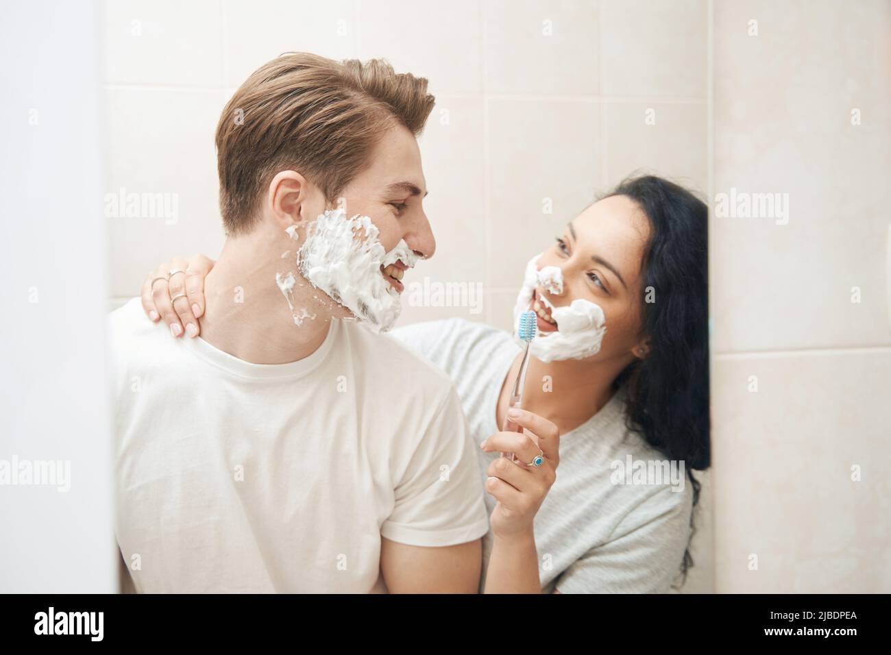 Cheerful couple having fun during morning routine Stock Photo - Alamy