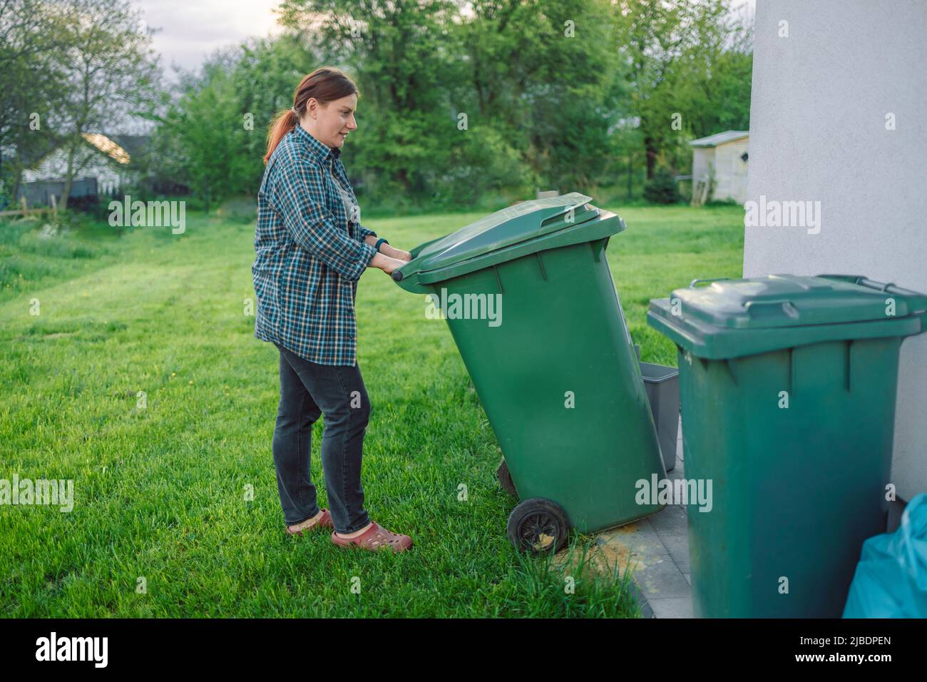 European 20s girl take out the trash can sorting garbage near a home ... European 20s girl take out the trash can sorting garbage near a home ...