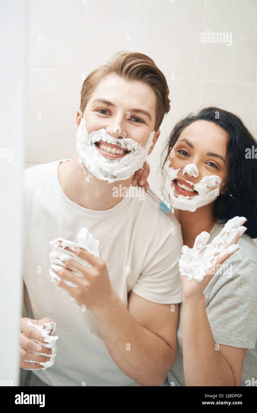 Joyful man and woman gazing at their reflection in mirror Stock Photo ...