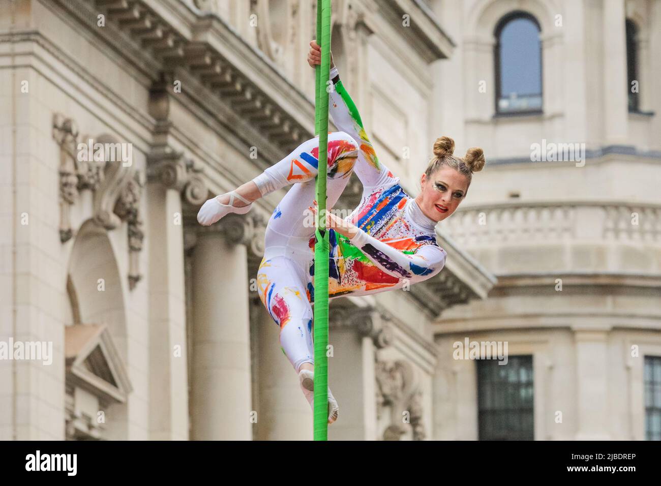 London, UK. 05th June, 2022. An acrobat dangles high in the air above a ...