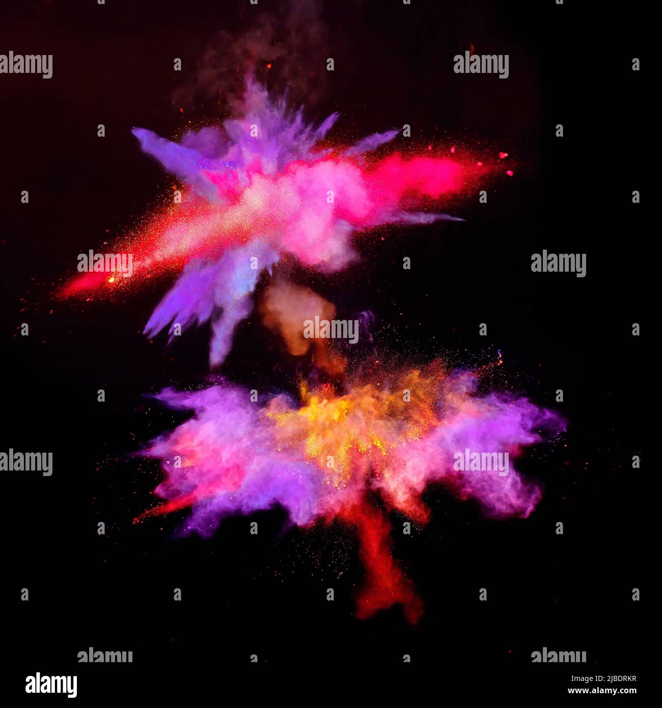 Various multicolored forms of powder paint explode in front of a black ...