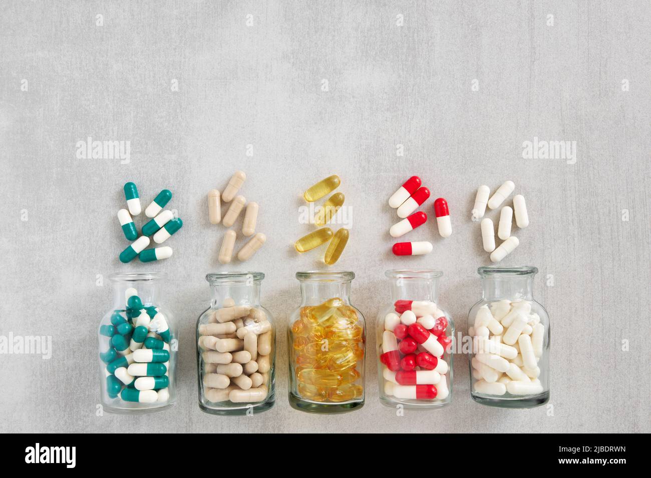 Five glass bottles of supplements pills. Variety of nutritional ...