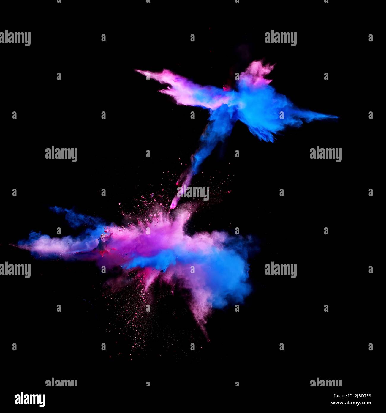 Various multicolored forms of powder paint explode in front of a black ...