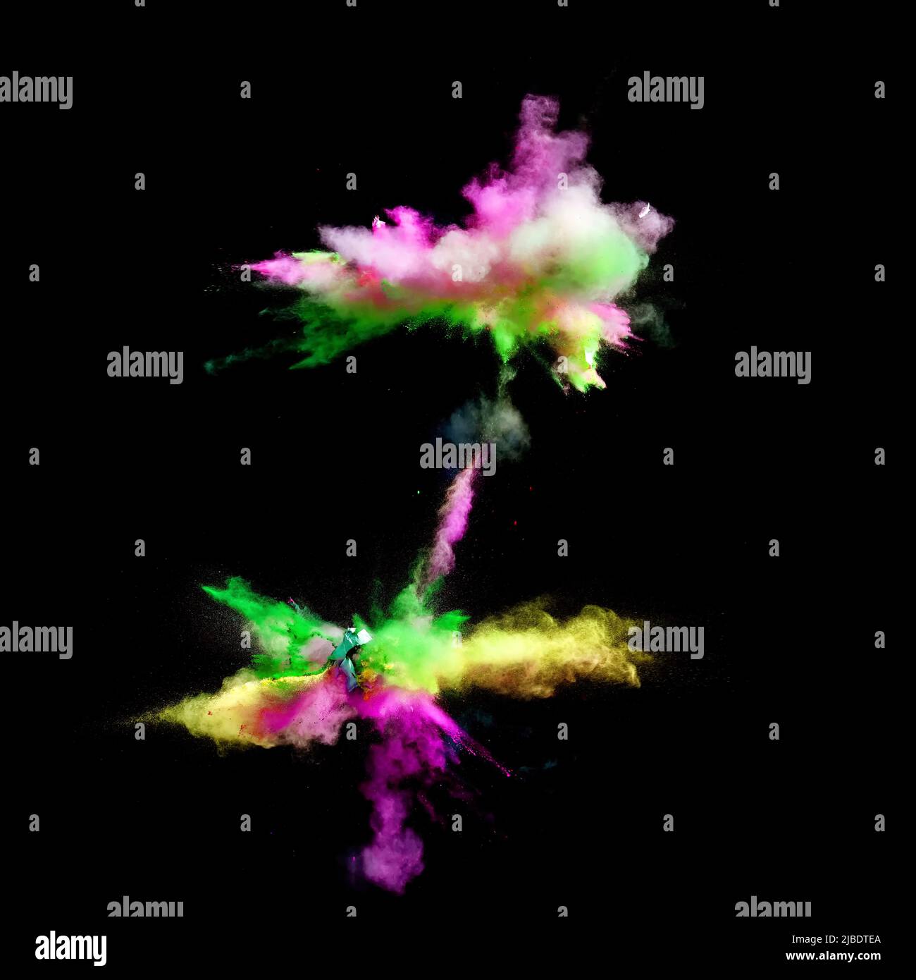 Various multicolored forms of powder paint explode in front of a black ...