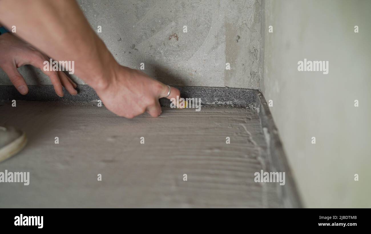 Reinforcing tape for drywall. Damper tape for screed. Worker glues ...