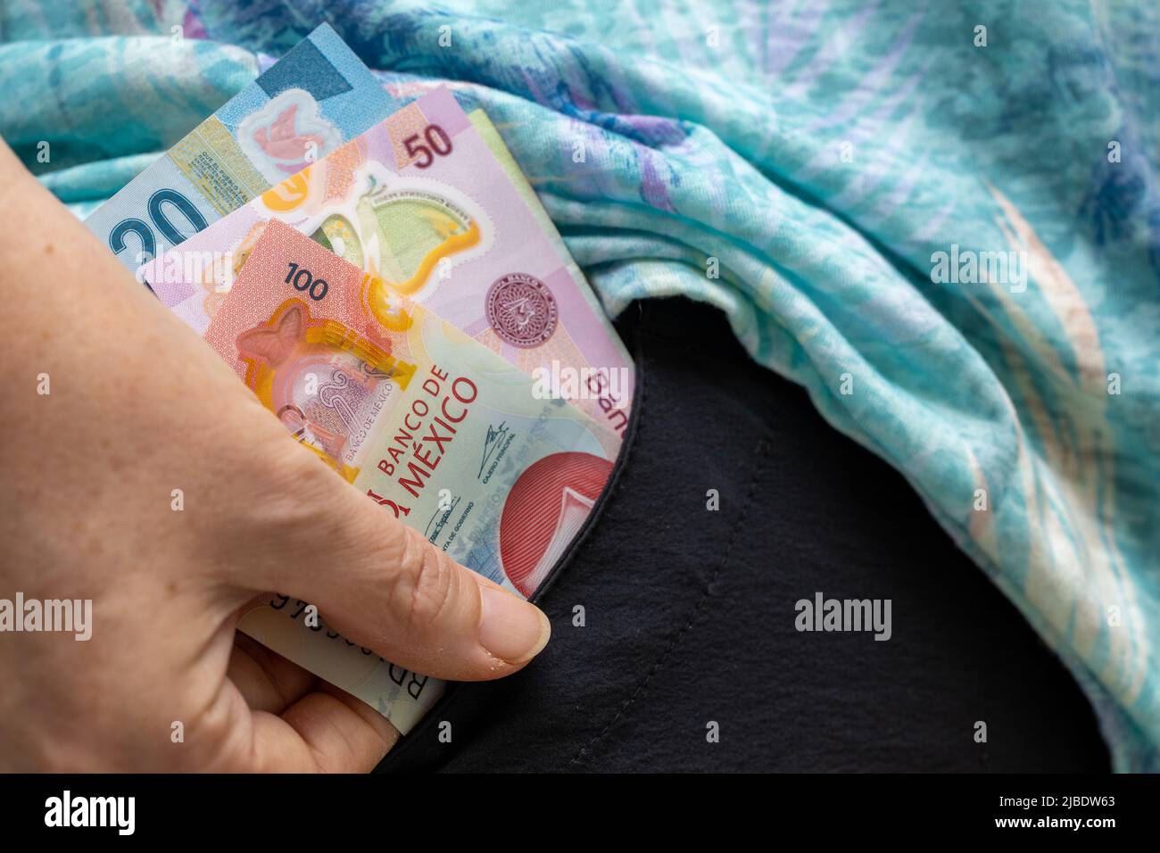 The woman pulls Mexican money, pesos bills from her pocket Stock Photo ...