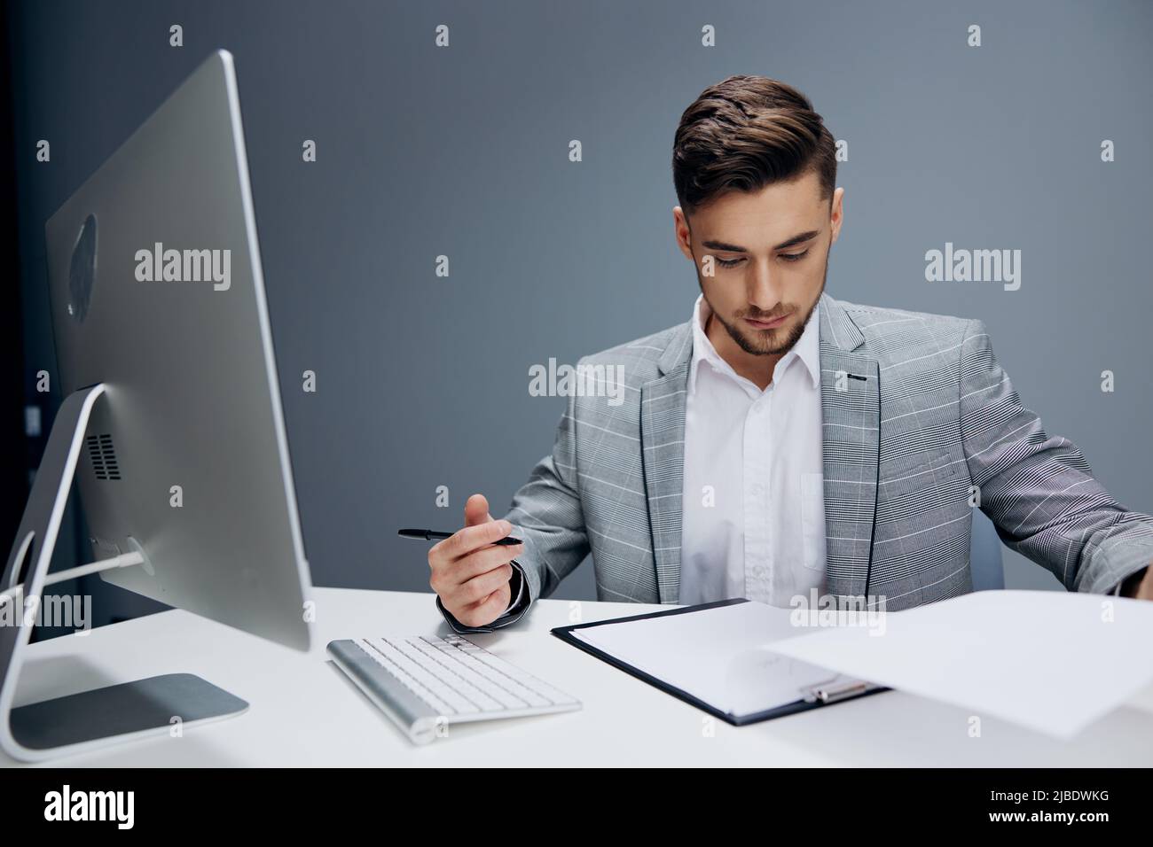 handsome man working at the computer in the office isolated background ...
