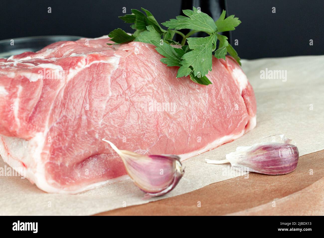 Raw meat steaks with garlic and meat knife, on kitchen cutting board ...