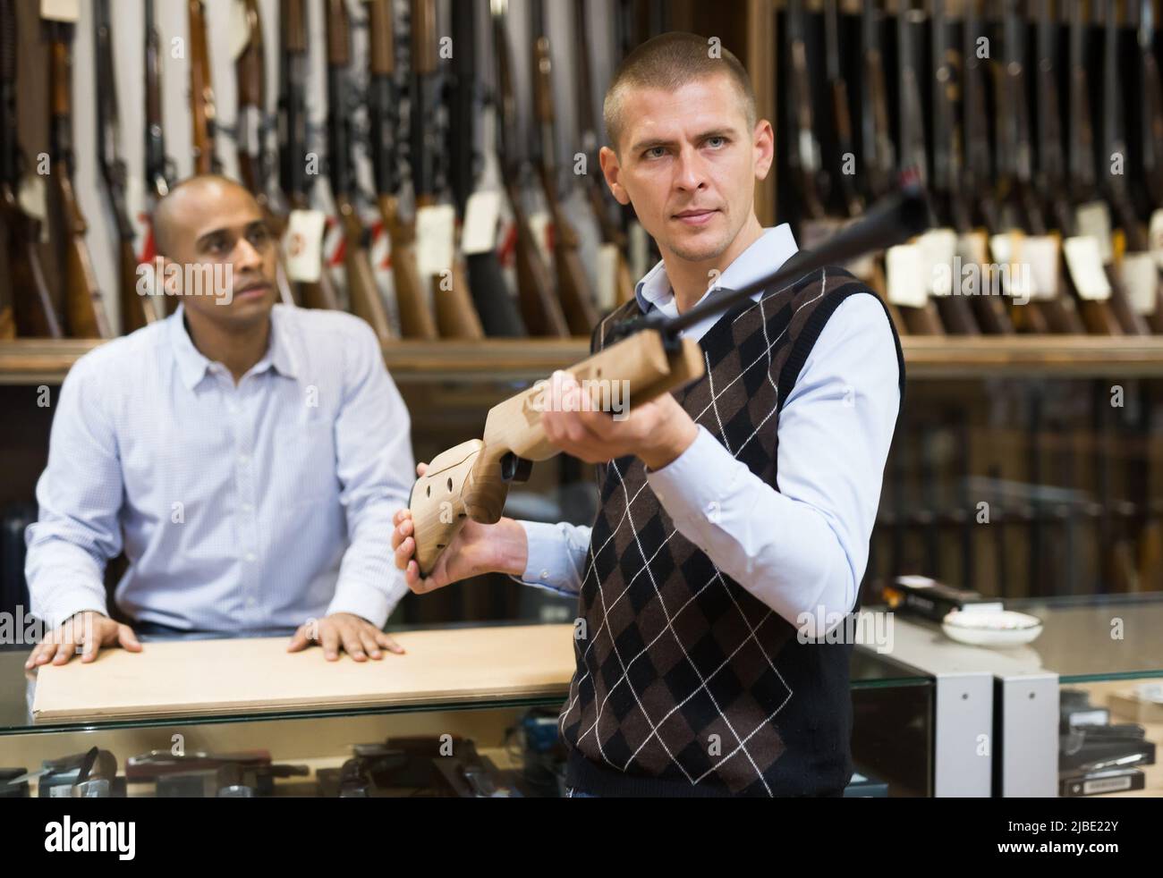 Man examining break-barrel air shotgun in gunsmith store Stock Photo ...