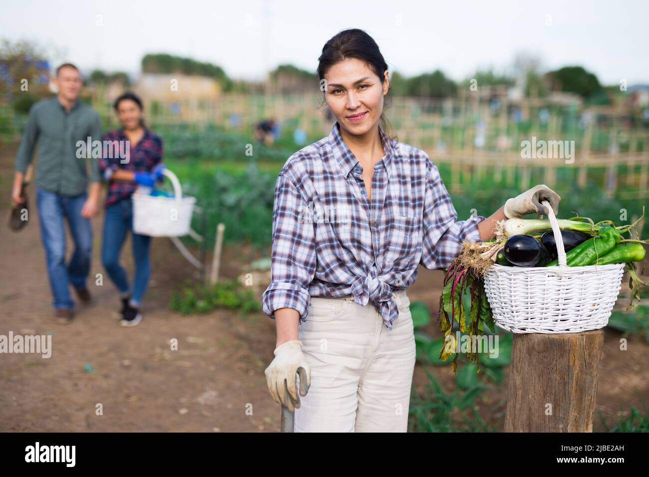 Happy asian woman showing vegetable crop in kitchen garden Stock Photo ...