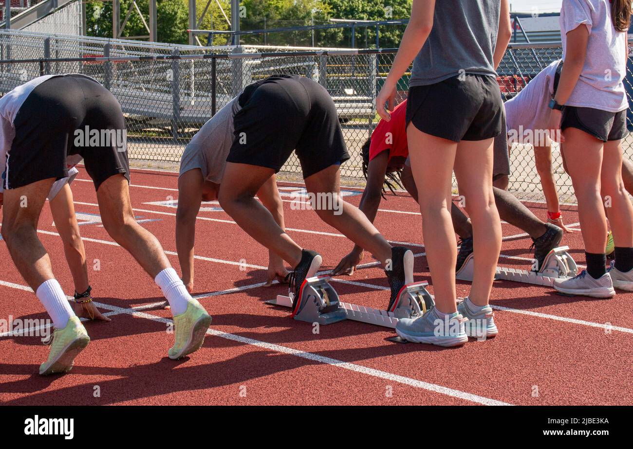 Four high school boys are set and in starting blocks ready to sprint ...