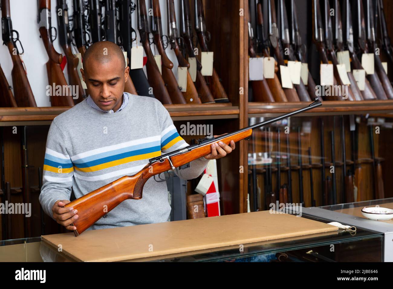 Gun shop salesman demonstrates combat rifle Stock Photo - Alamy