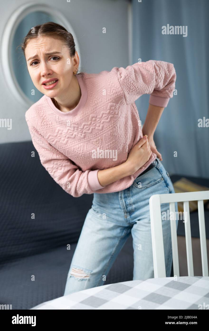 Woman suffering from back pain at home Stock Photo - Alamy