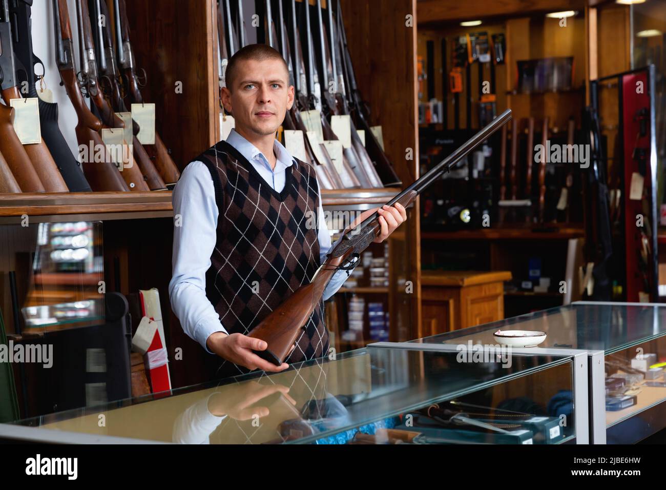 Owner of armory shop offering vintage hunting rifle Stock Photo - Alamy