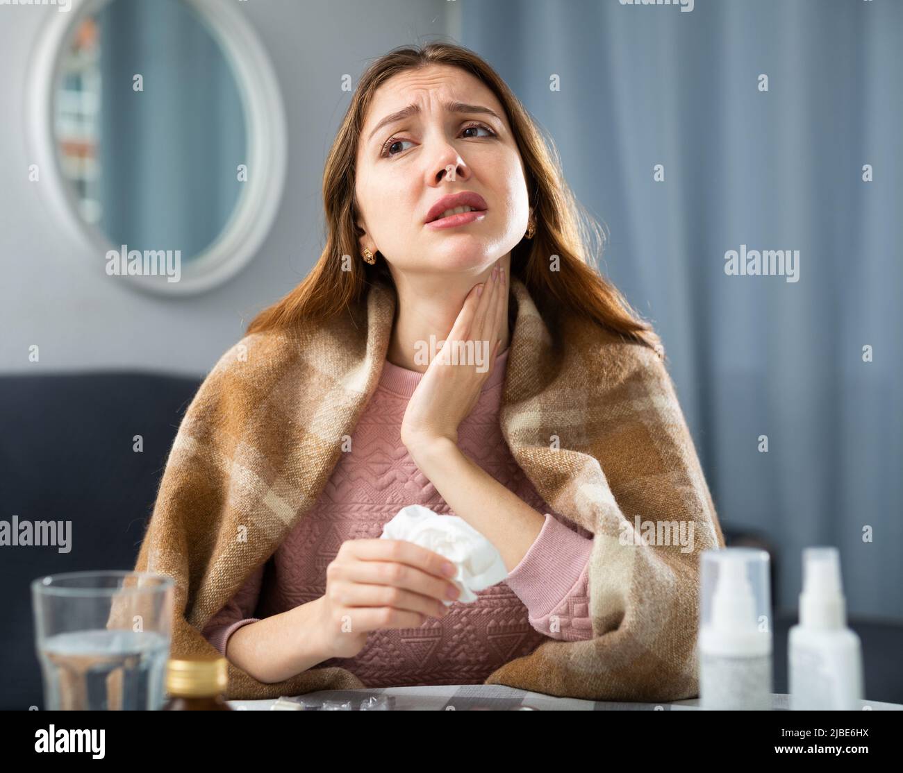 Portrait of sick woman sitting at table at home Stock Photo - Alamy