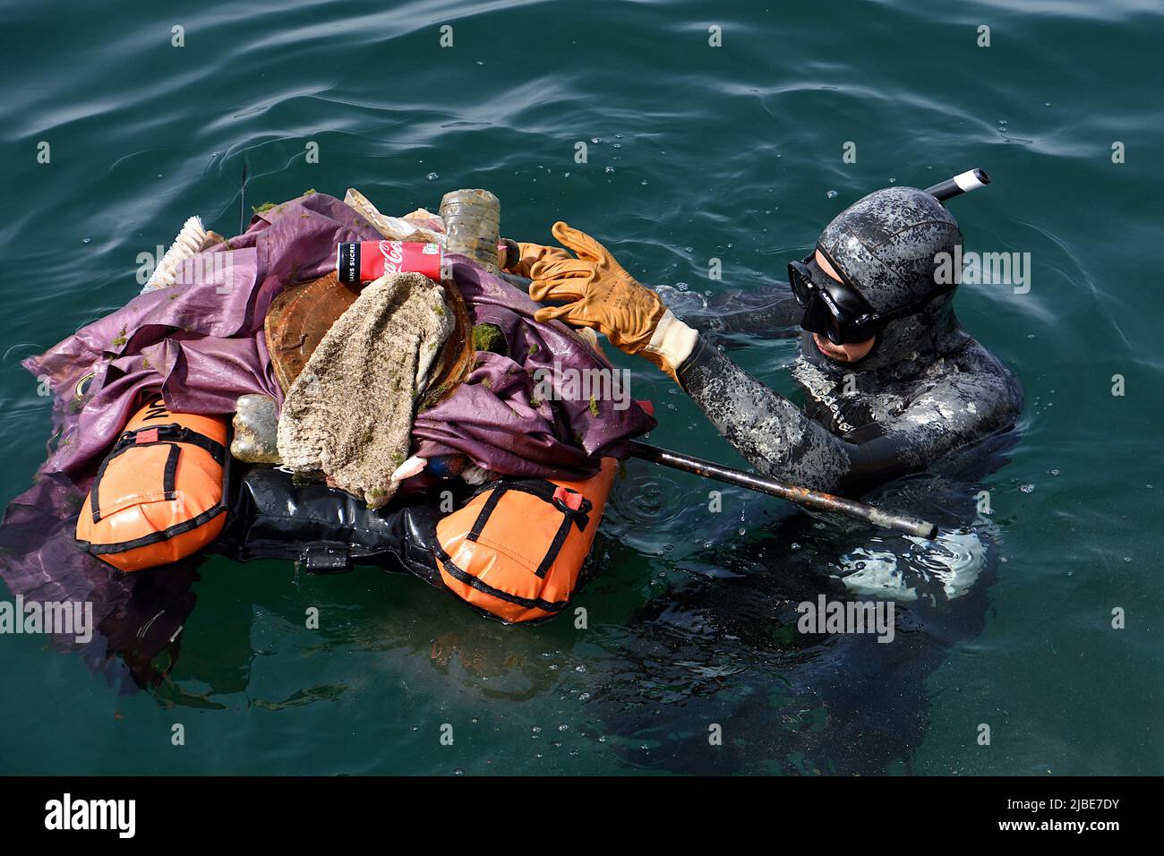A diver is seen with waste during collection. About forty volunteers ...