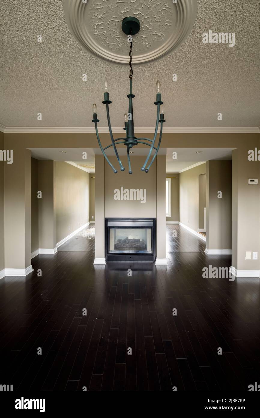 A chandelier and a gas fireplace in an otherwise empty room. This house ...