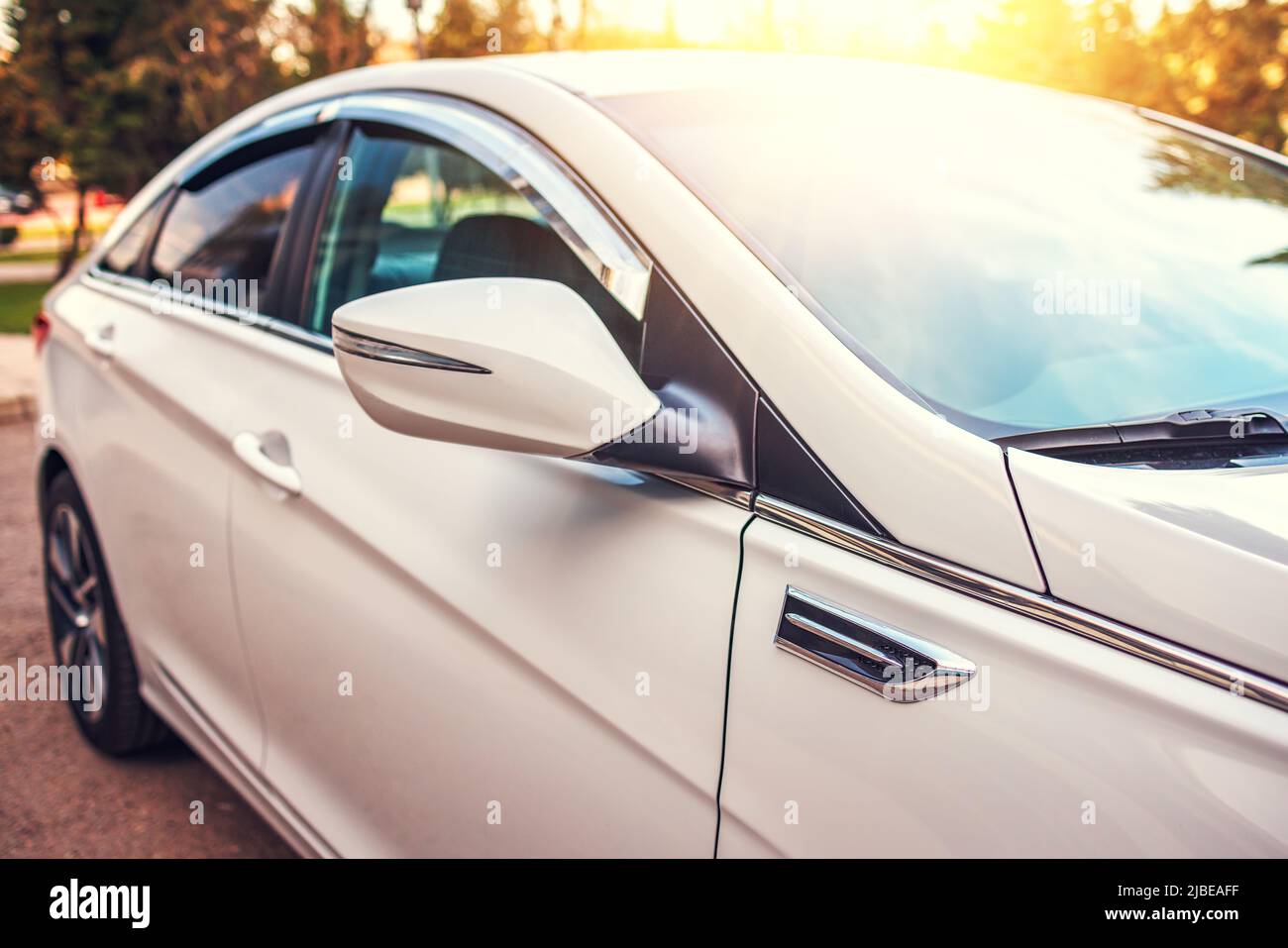 Modern car on a city street and sunshine over windows Stock Photo - Alamy