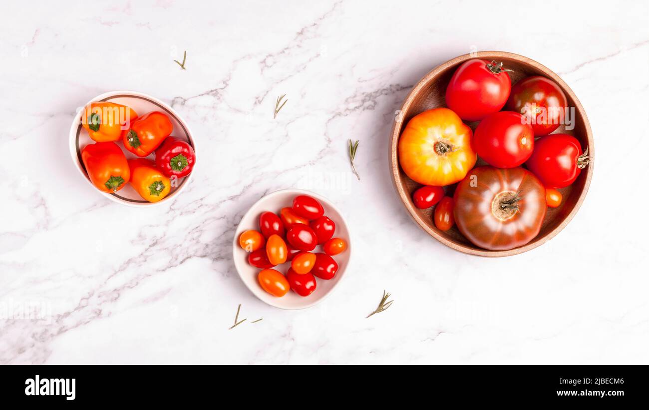 Three bowls with different types and colors of tomatoes and mini bell ...