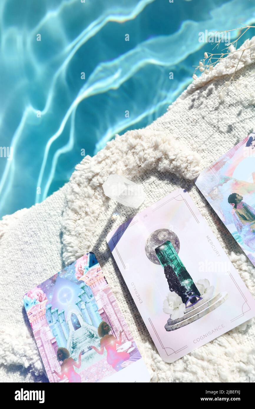 Oracle cards and clear quartz crystal on poolside bohemian picnic rug ...