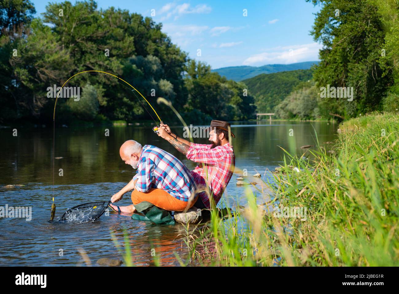 Two men friends fishing. Flyfishing angler makes cast, standing in ...