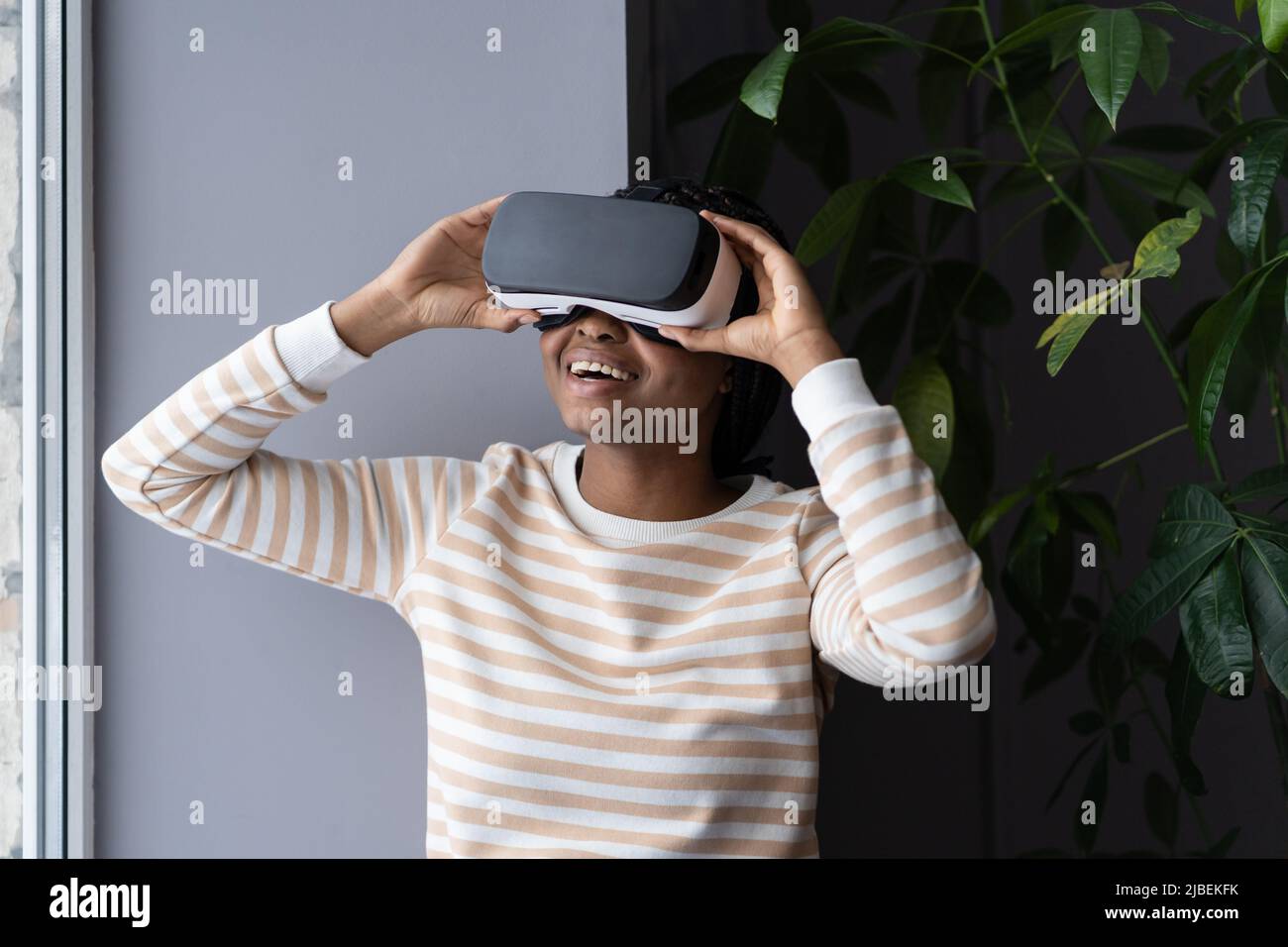 Amazed african american woman testing modern high-tech VR helmet ...