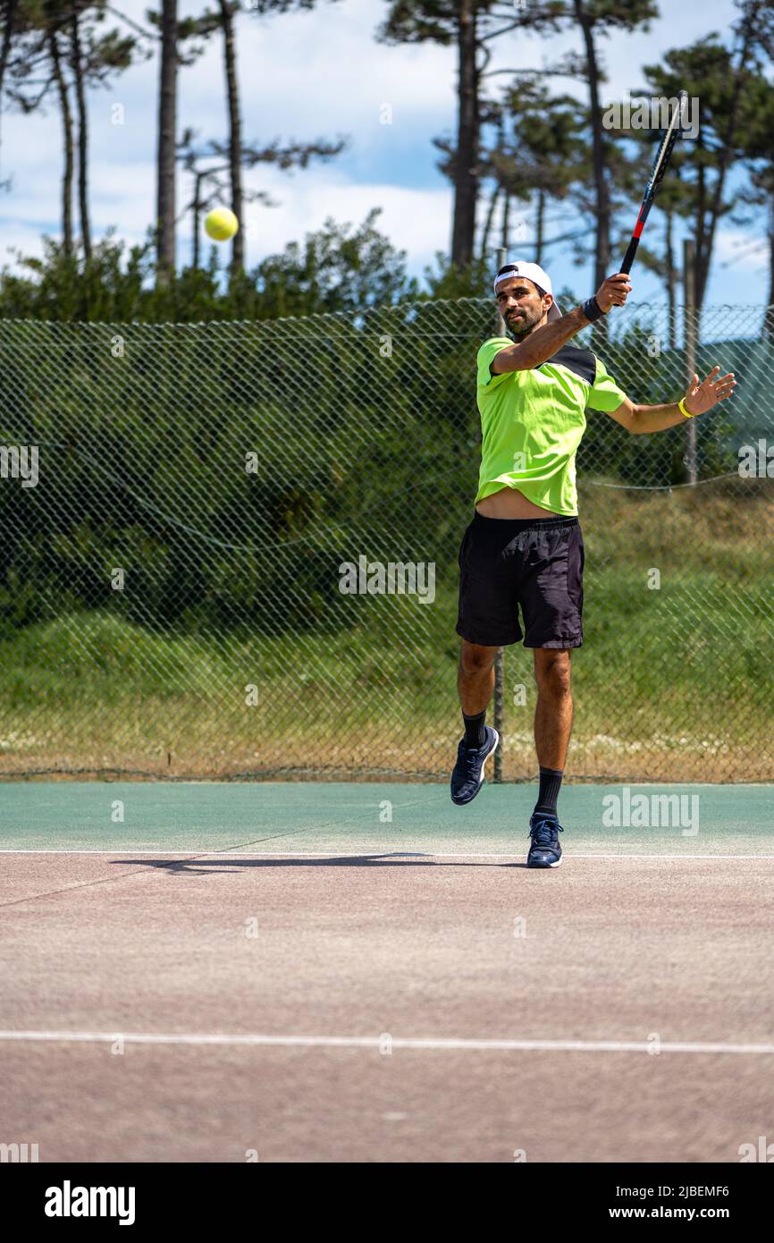 Tennis player performing a smash on court Stock Photo - Alamy