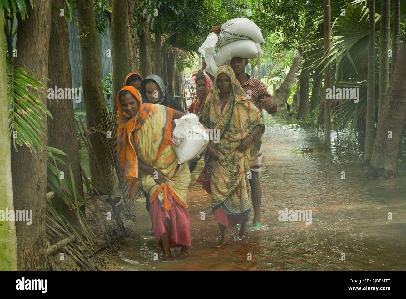 Women returning after collecting relief which is distributed due to ...